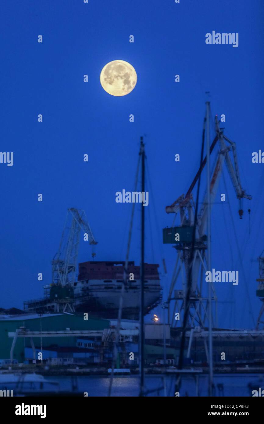 Strawberry Full Moon sets behind cranes at Uljanik Shipyard, in Pula ...