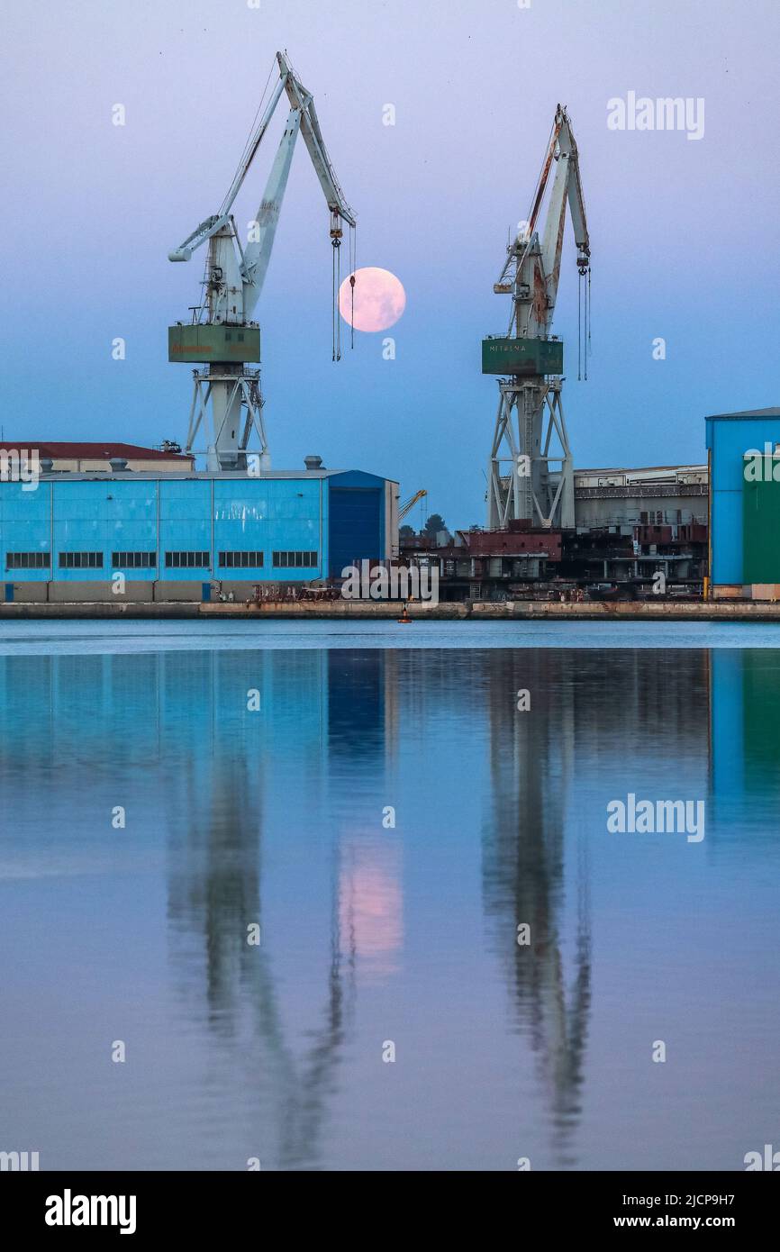 Strawberry Full Moon sets behind cranes at Uljanik Shipyard, in Pula ...