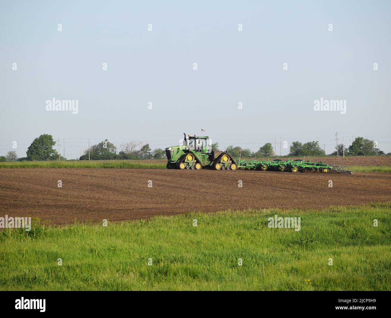 A farmer driving a John Deere 9620 RX tractor on a field in rural east ...