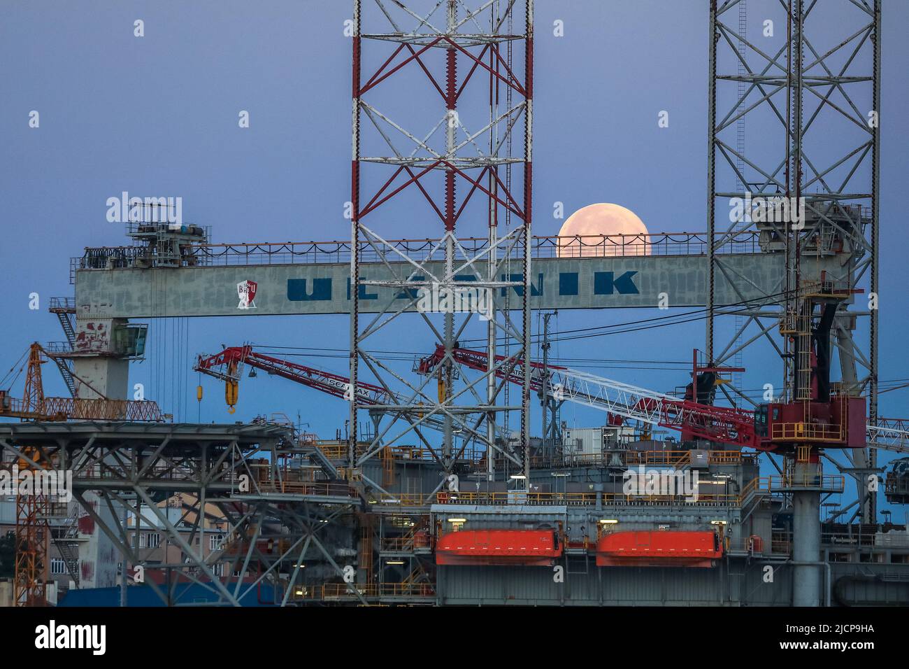 Strawberry Full Moon sets behind cranes at Uljanik Shipyard, in Pula ...