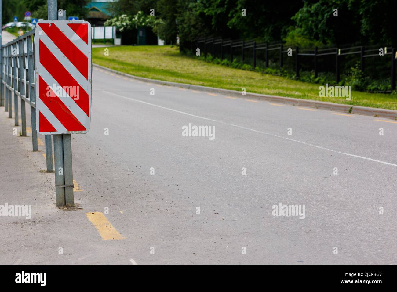 red and white diagonal striped sign at road fence end Stock Photo - Alamy