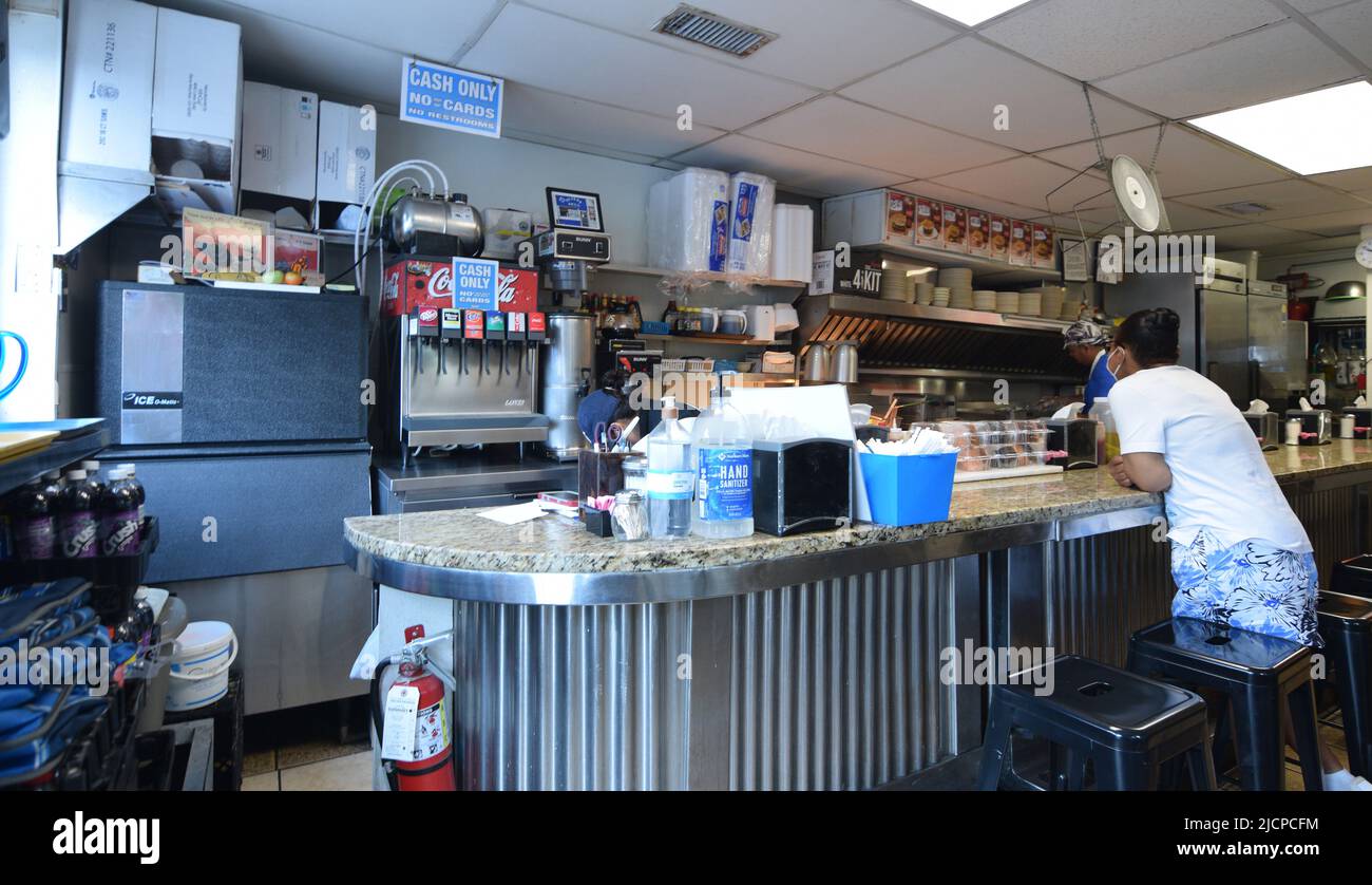 A hungry customer, wearing a mask, waits for her food at the Record ...
