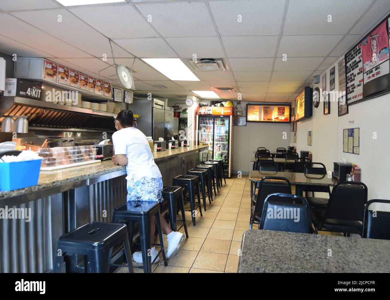 A hungry customer, wearing a mask, waits for her food at the Record ...