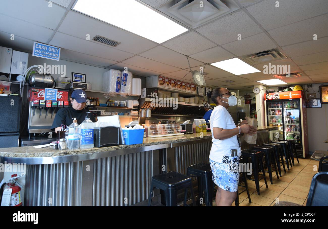 A hungry customer, wearing a mask, waits for her food at the Record ...