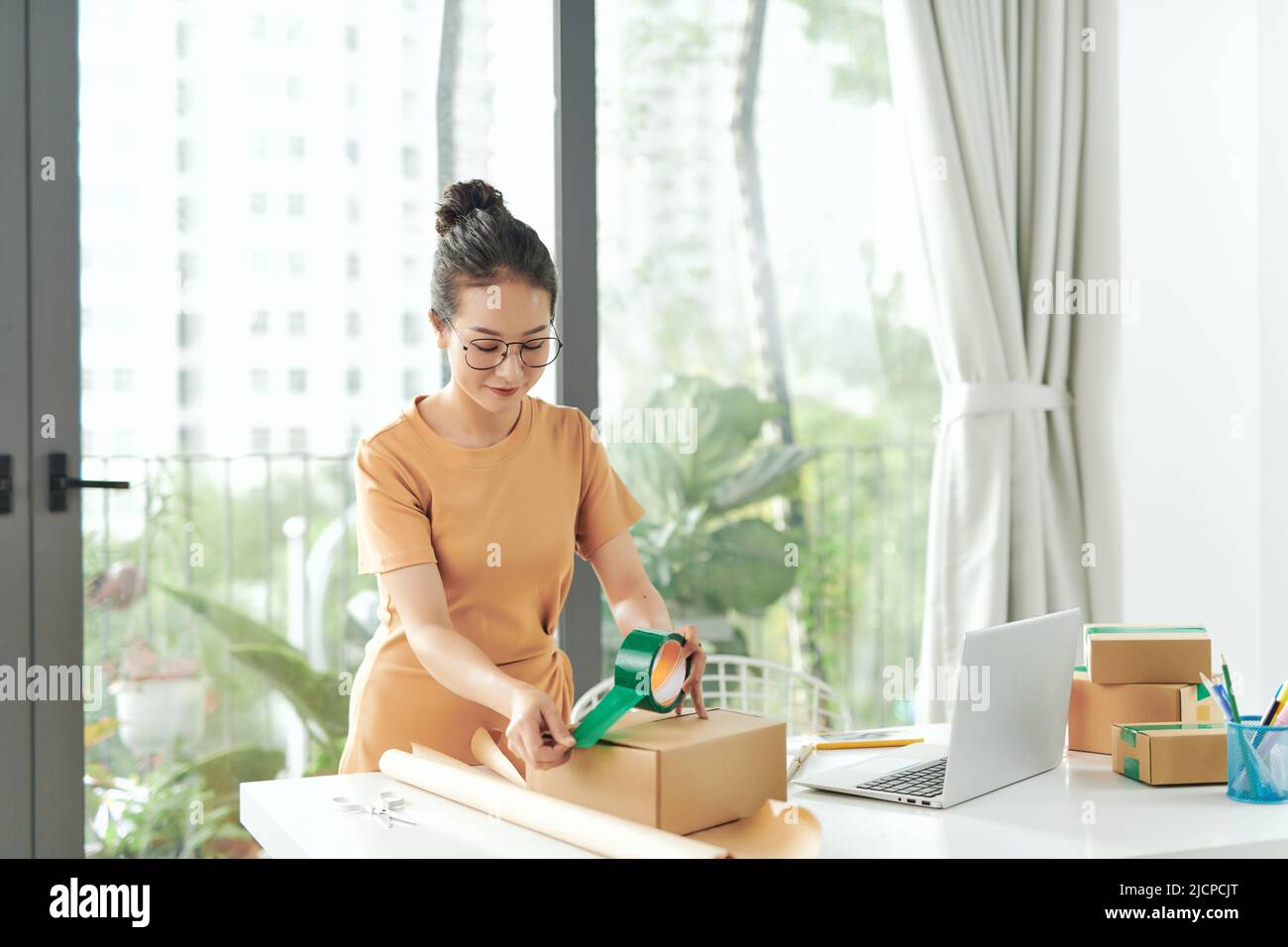 Online merchants packing items into paper boxes Stock Photo - Alamy