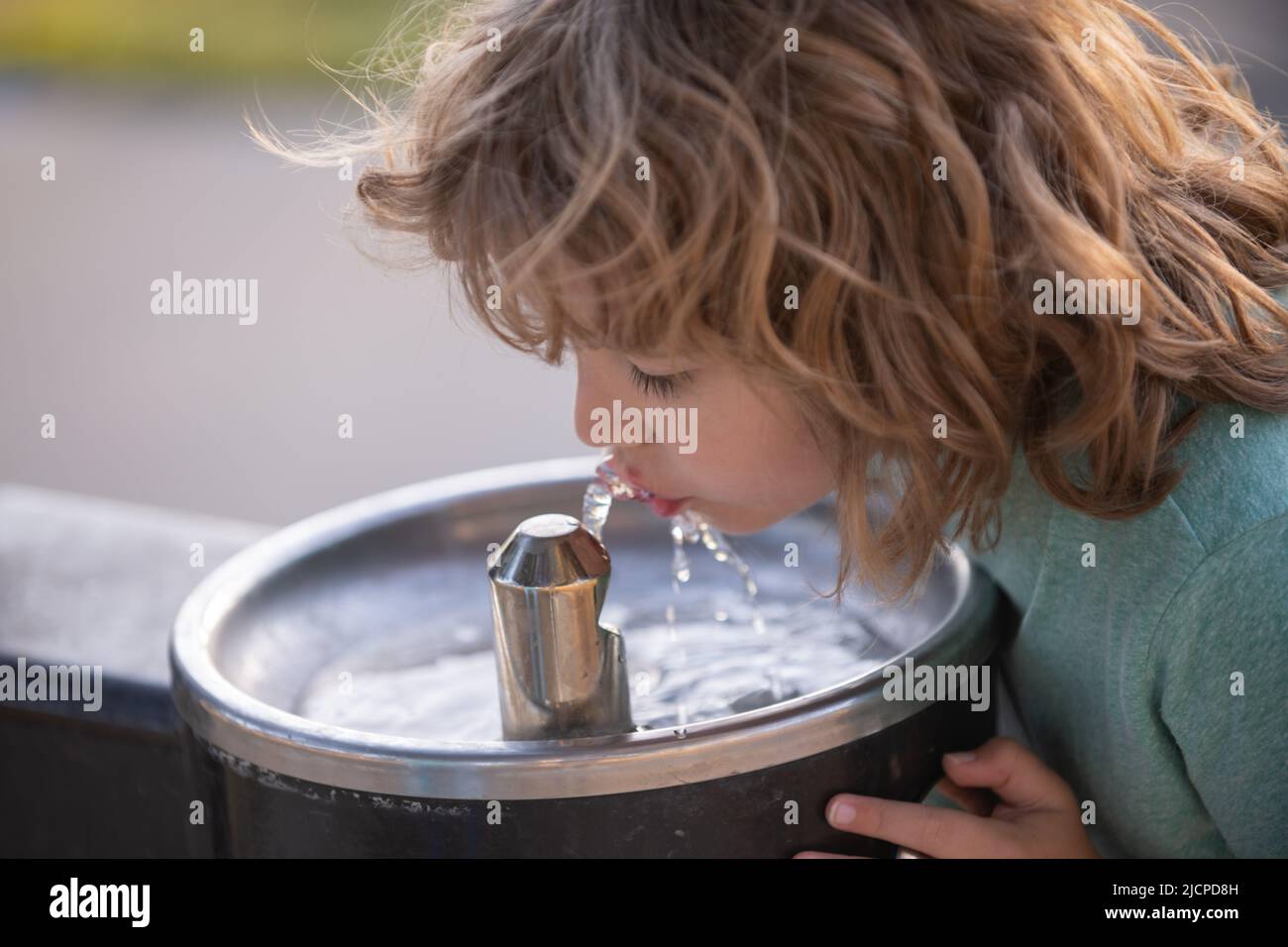 Face close up portrait of child drinking water from tap or water ...