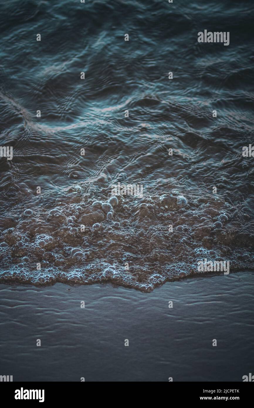 Wave washing onto the beach Stock Photo - Alamy