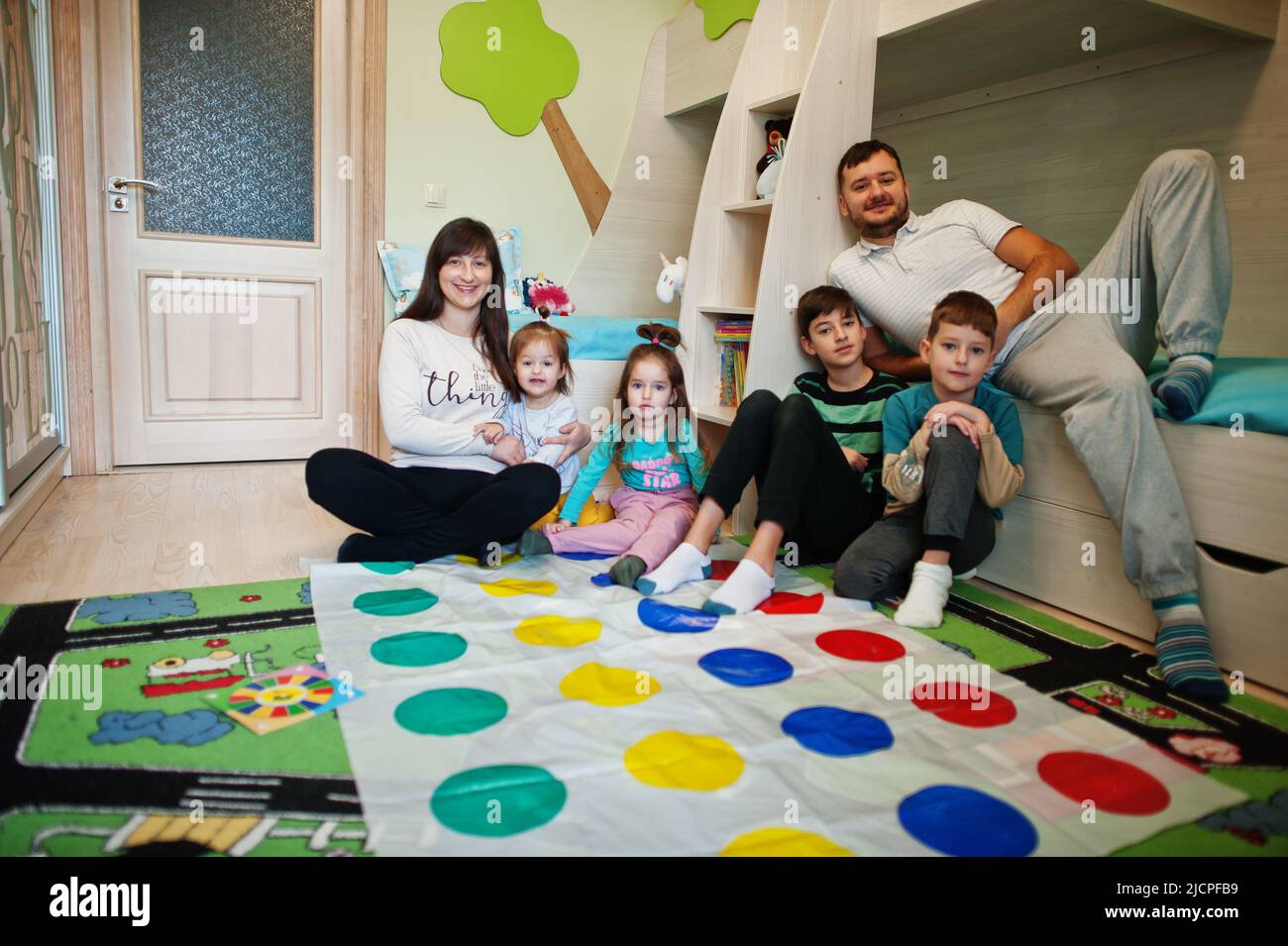 Happy big family having fun together,four kids playing twister game at ...