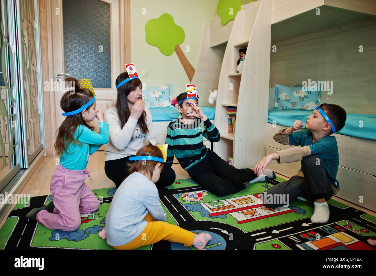 Happy family with four kids playing game guess who while having fun at ...