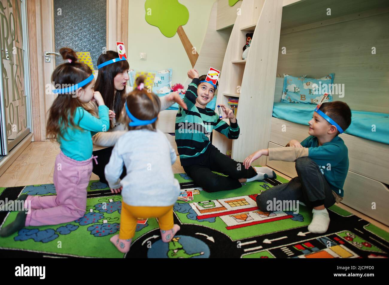 Happy family with four kids playing game guess who while having fun at ...
