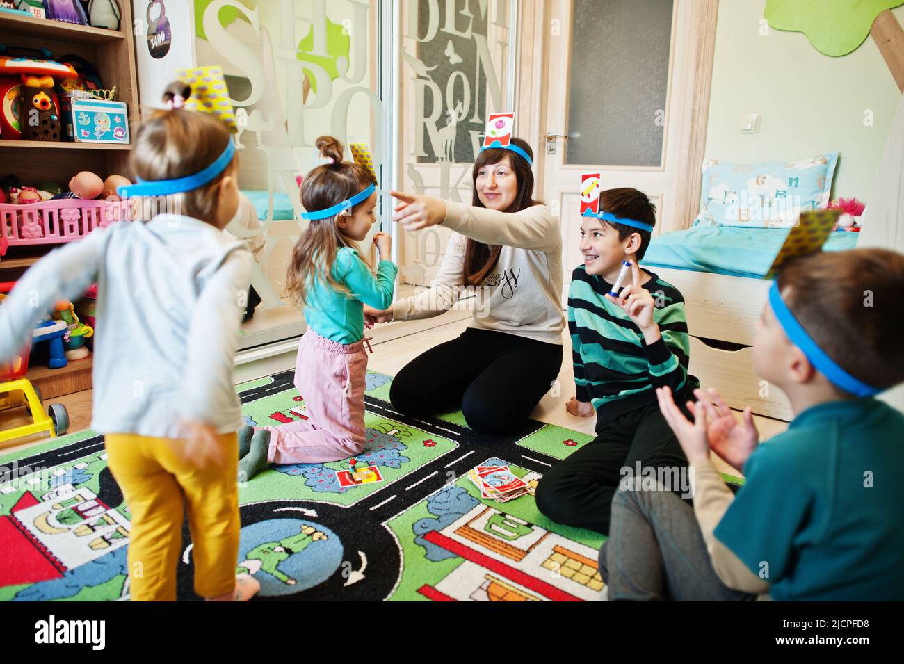 Happy family with four kids playing game guess who while having fun at ...