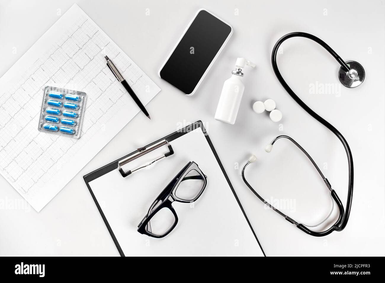Doctor's office desk with medical documents, charts, eyeglasses and ...