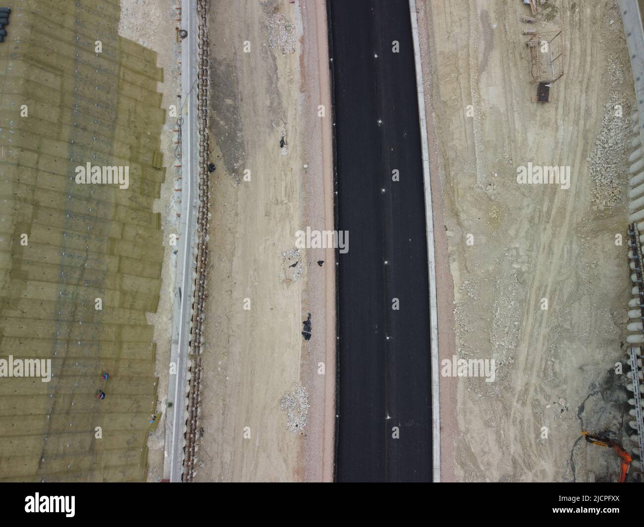 Workers reinforce the slope over the new road. Road construction in ...