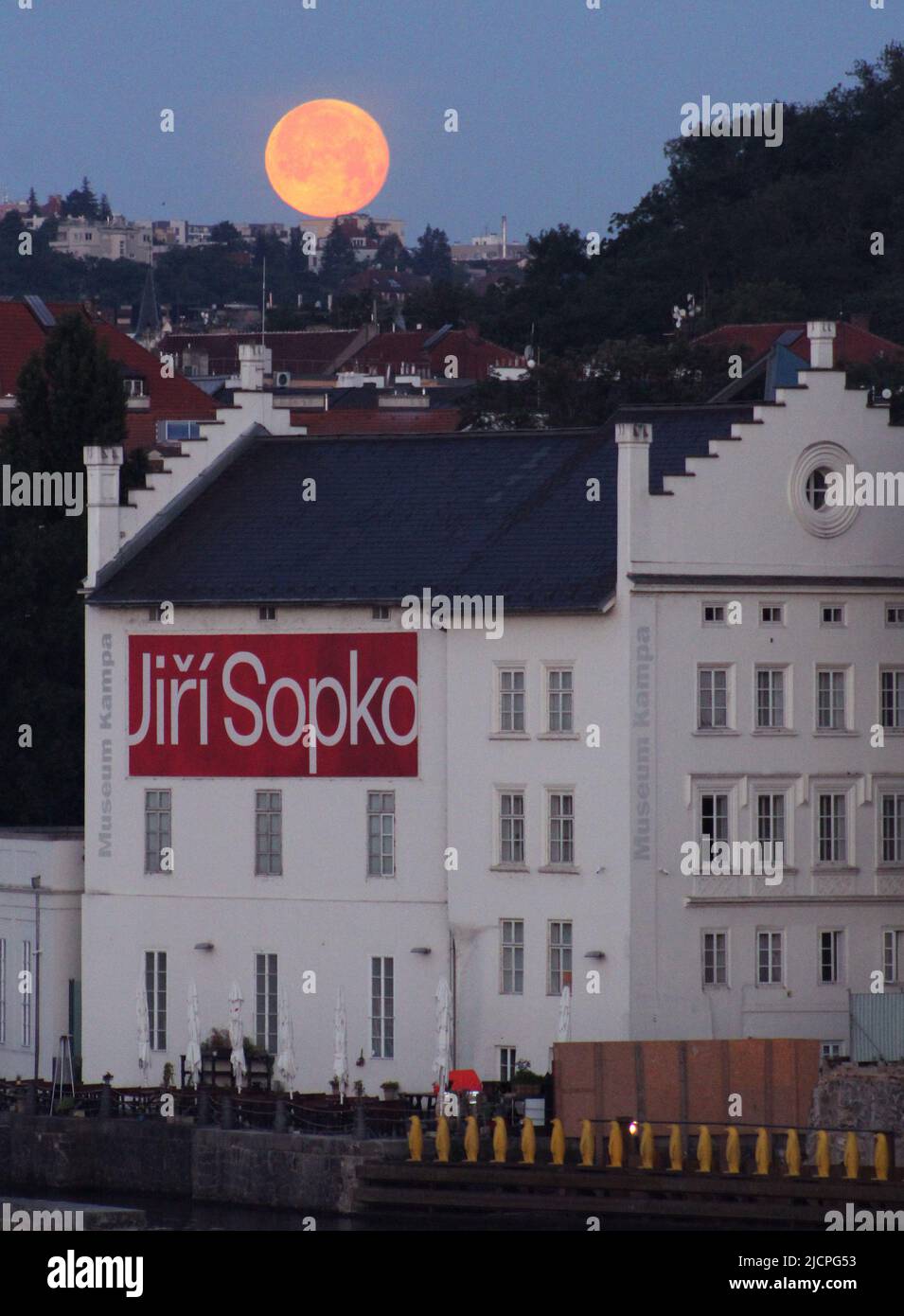A full moon rises behind the Prague, Czech Republic, June 14, 2022. The ...