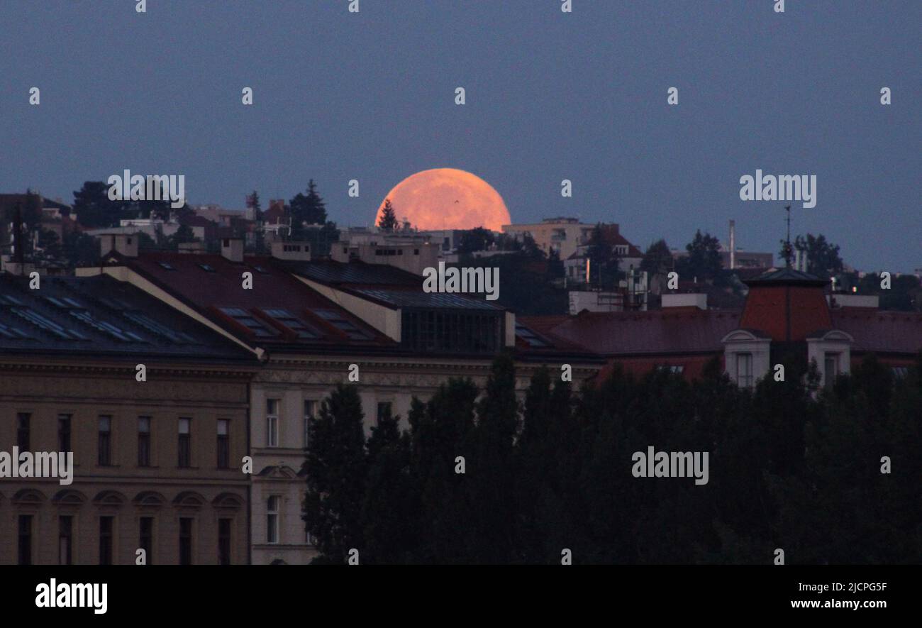 A full moon rises behind the Prague, Czech Republic, June 14, 2022. The ...