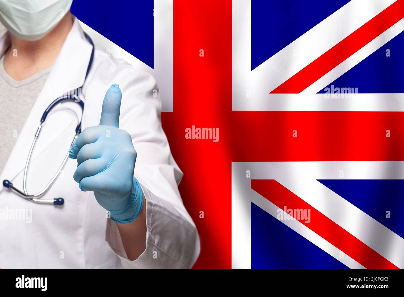 UK doctor's hand showing thumb up positive gesture on flag of United ...