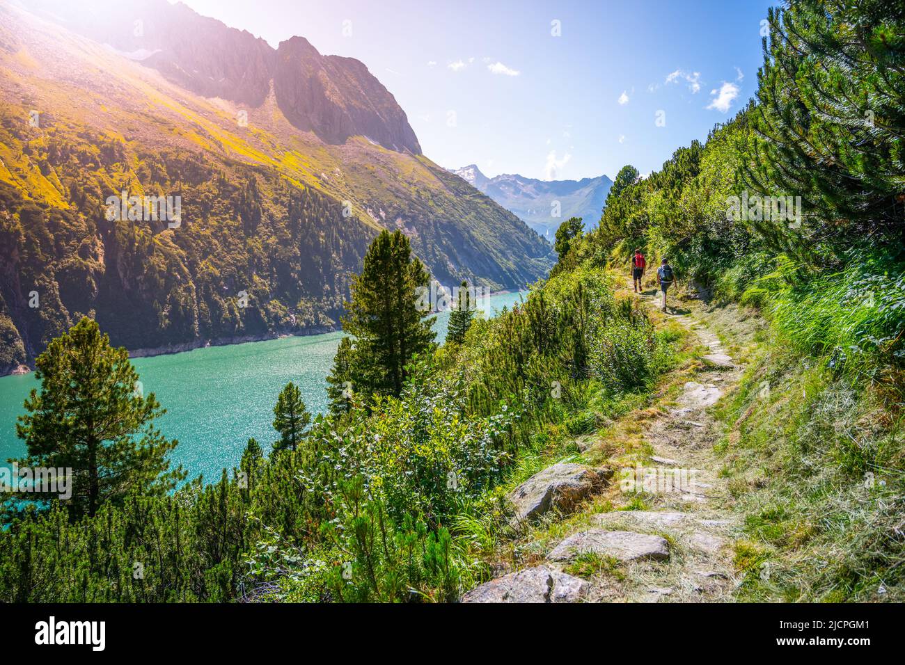 Alpine track and two hikers at mountain lake Stock Photo - Alamy