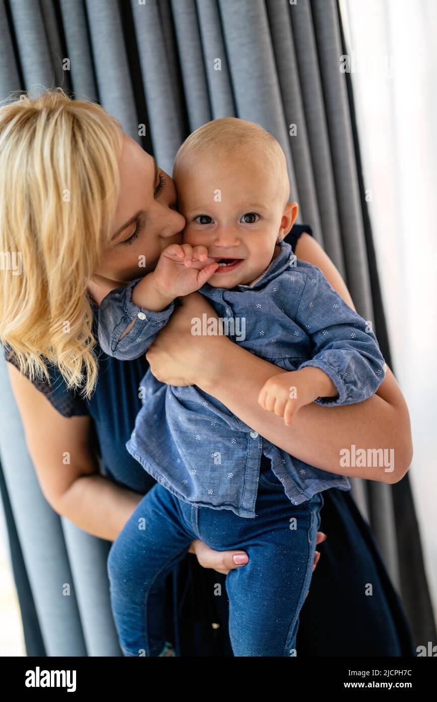 Happy family indoors. Portrait of beautiful mother with cute baby playing smiling together Stock ...
