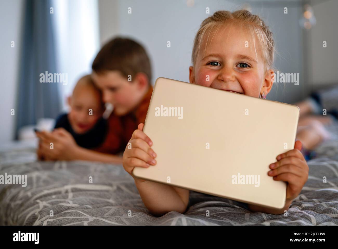 Portrait of happy children using digital devices and having fun ...