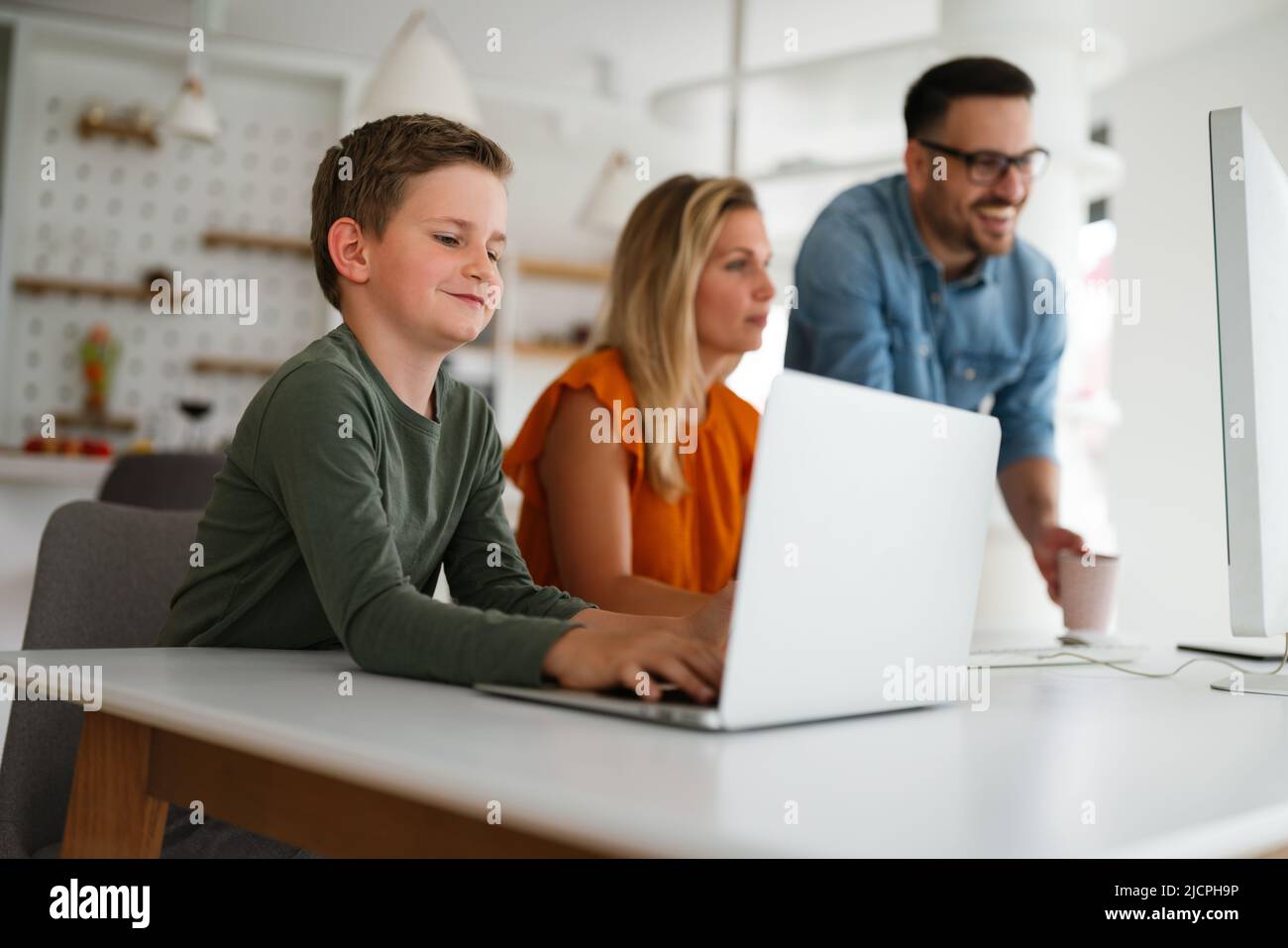 Happy family parent and child at home working on the computer. Business ...