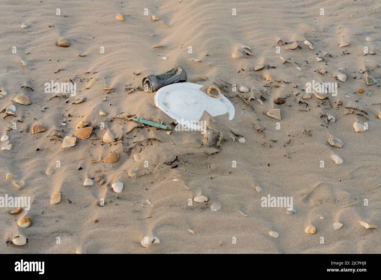 Debris and trash left by people or washed up on the beach from boats at ...