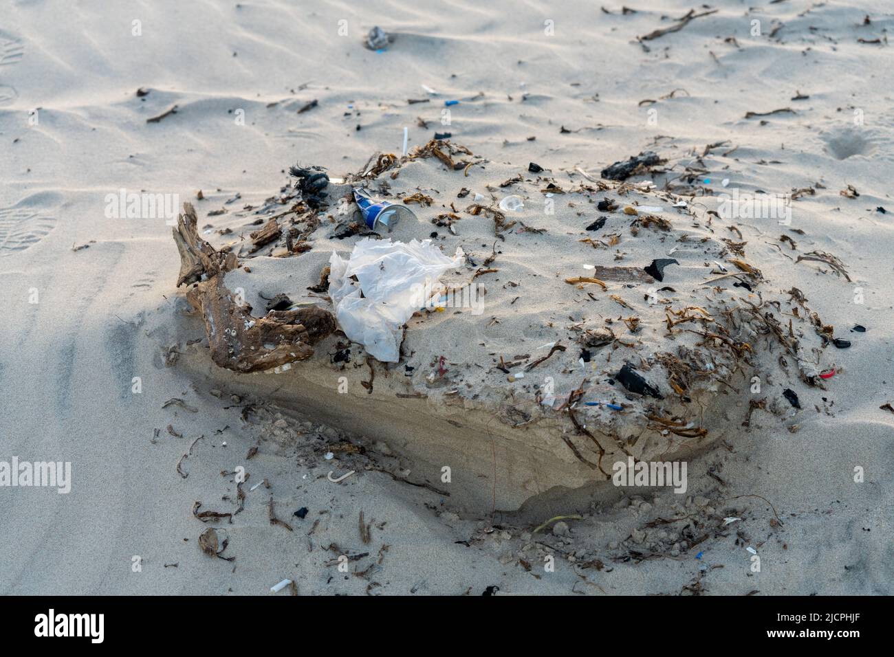Debris and trash left by people or washed up on the beach from boats at ...