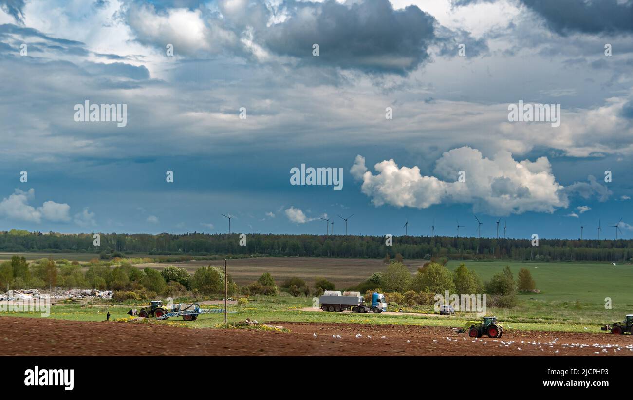 Spring sowing work on the field. Tractors with sowers on the field in ...
