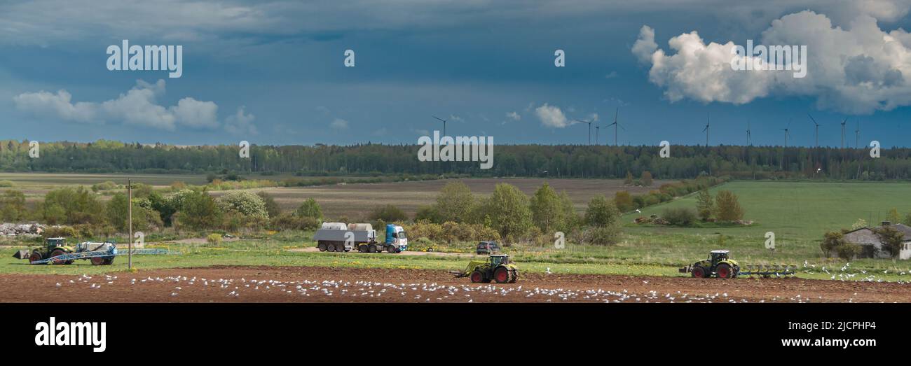 Spring sowing work on the field. Tractors with sowers on the field in ...