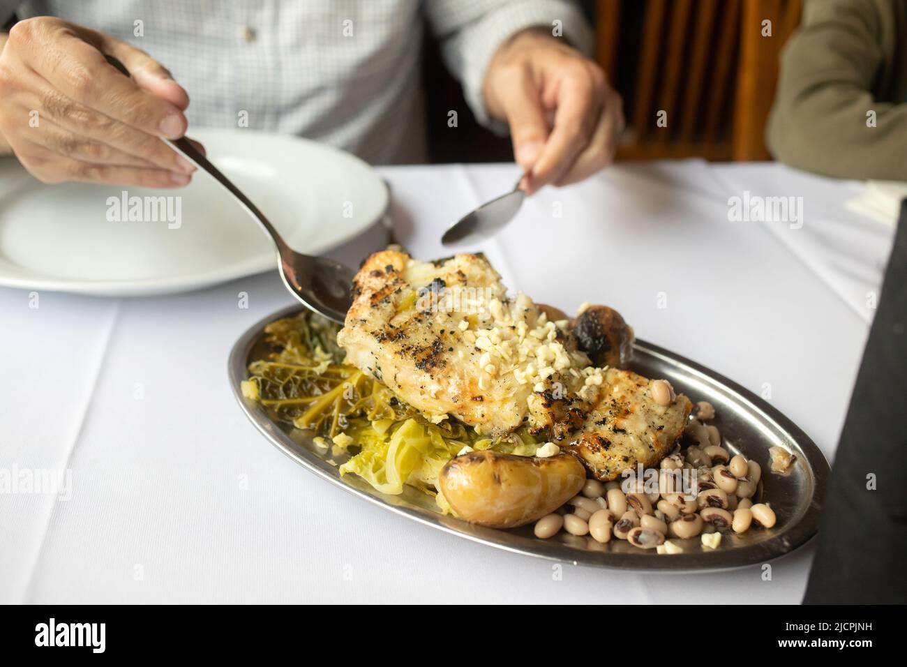 man eating grilled cod fish in restaurante Stock Photo - Alamy