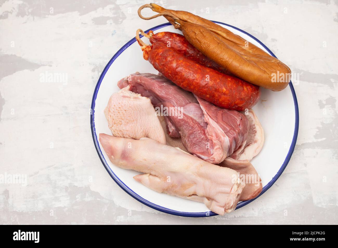 raw meat, pork ear and smoked sausages on white dish Stock Photo - Alamy