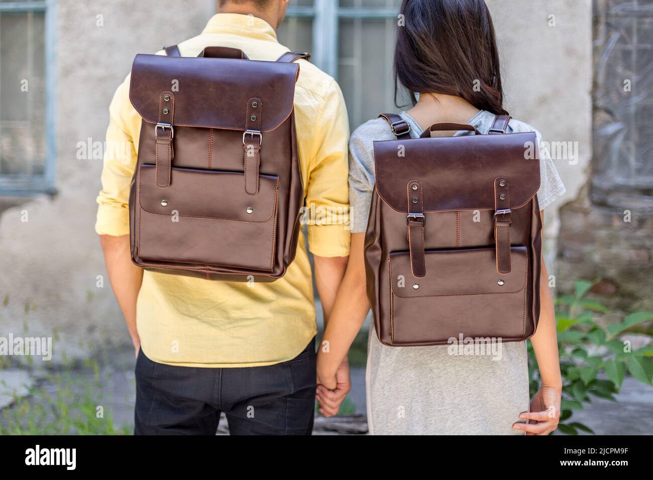 Back of woman and man with brown leather backpack. Man and woman ...
