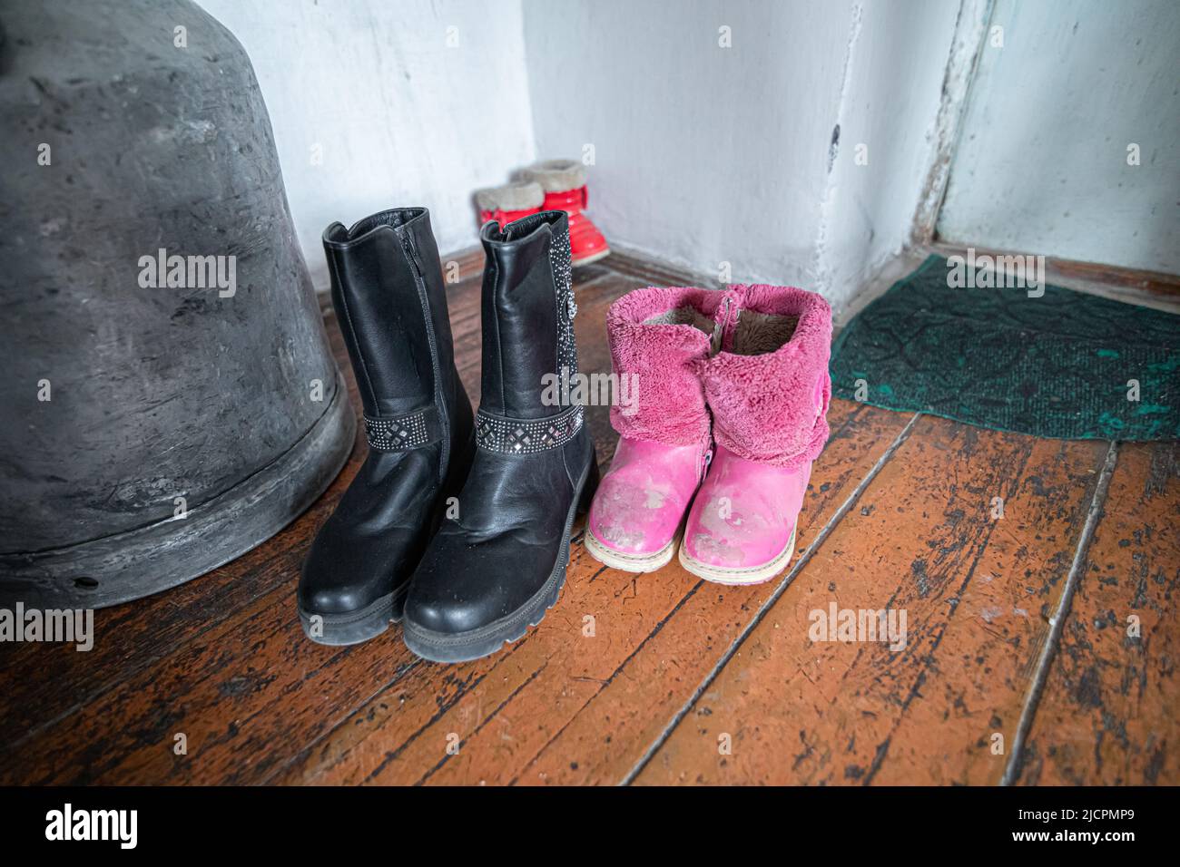 Kids old winter boots laying on the wooden floor Stock Photo - Alamy