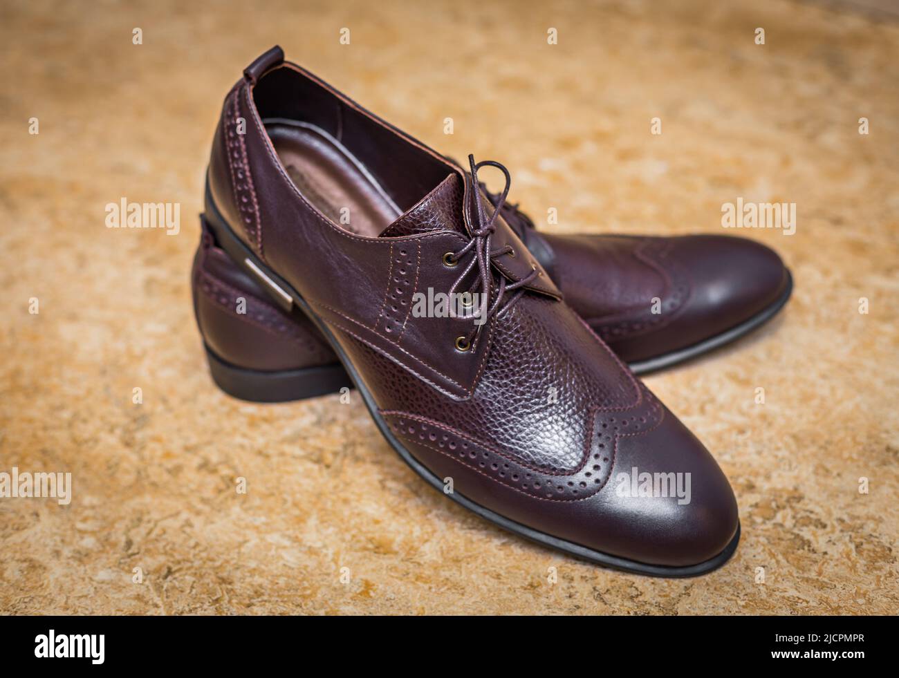 Closeup men's brown brogues on a beige background Stock Photo - Alamy