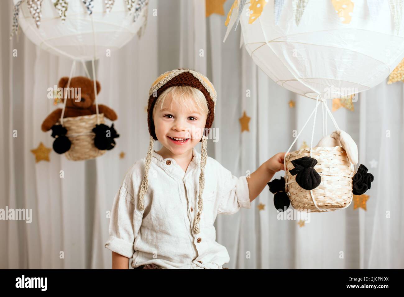 Sweet toddler boy, playing with airplane and teddy bear, decorated air ...