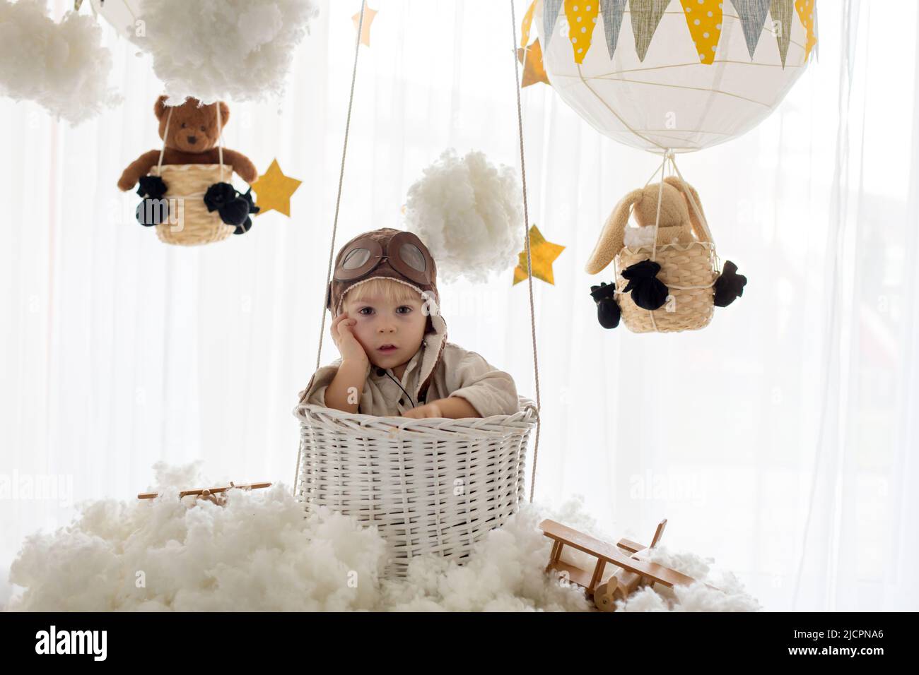 Sweet toddler boy, playing with airplane and teddy bear, decorated air ...