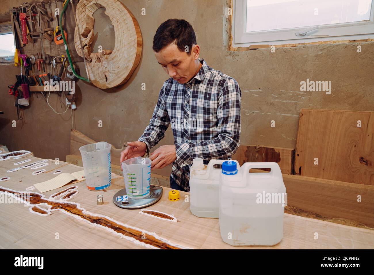 Carpenter preparing epoxy resin. Process of making a craft resin and ...
