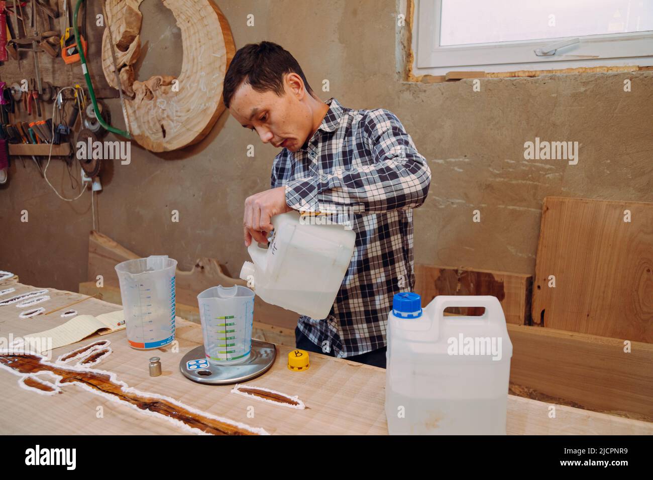 Carpenter preparing epoxy resin. Process of making a craft resin and ...