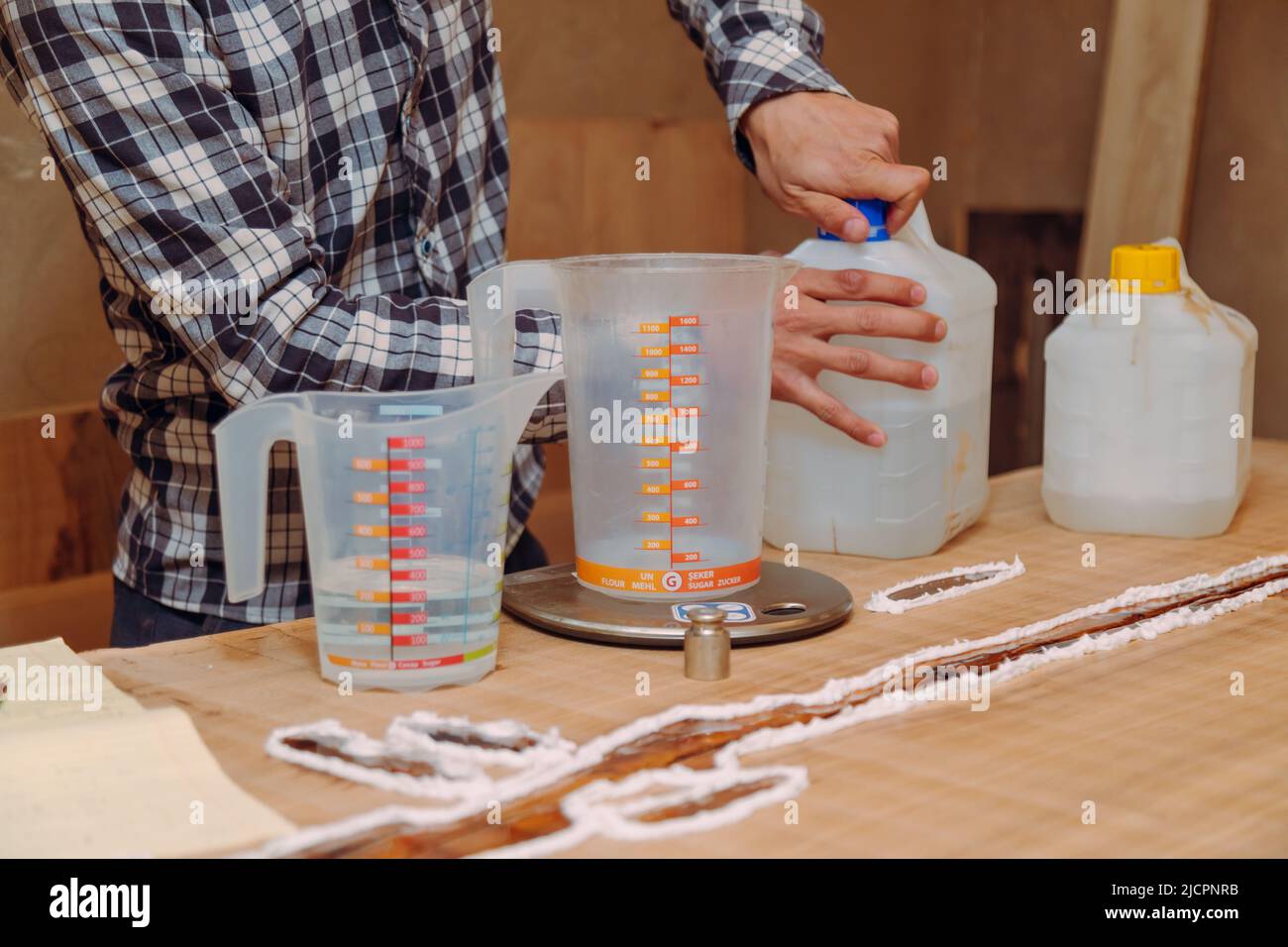 Closeup carpenter preparing epoxy resin. Process of making a craft ...