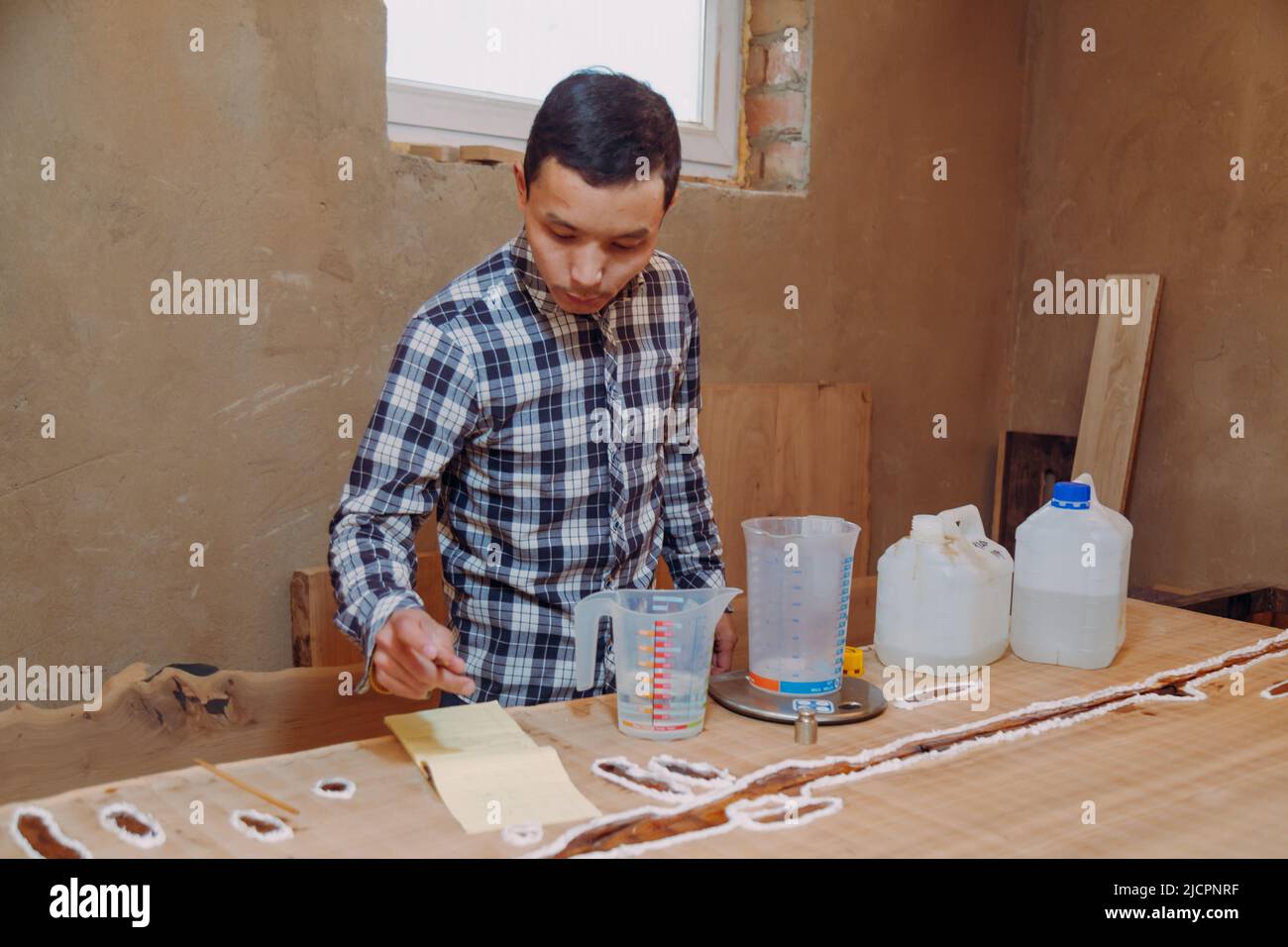 Carpenter preparing epoxy resin. Process of making a craft resin and ...