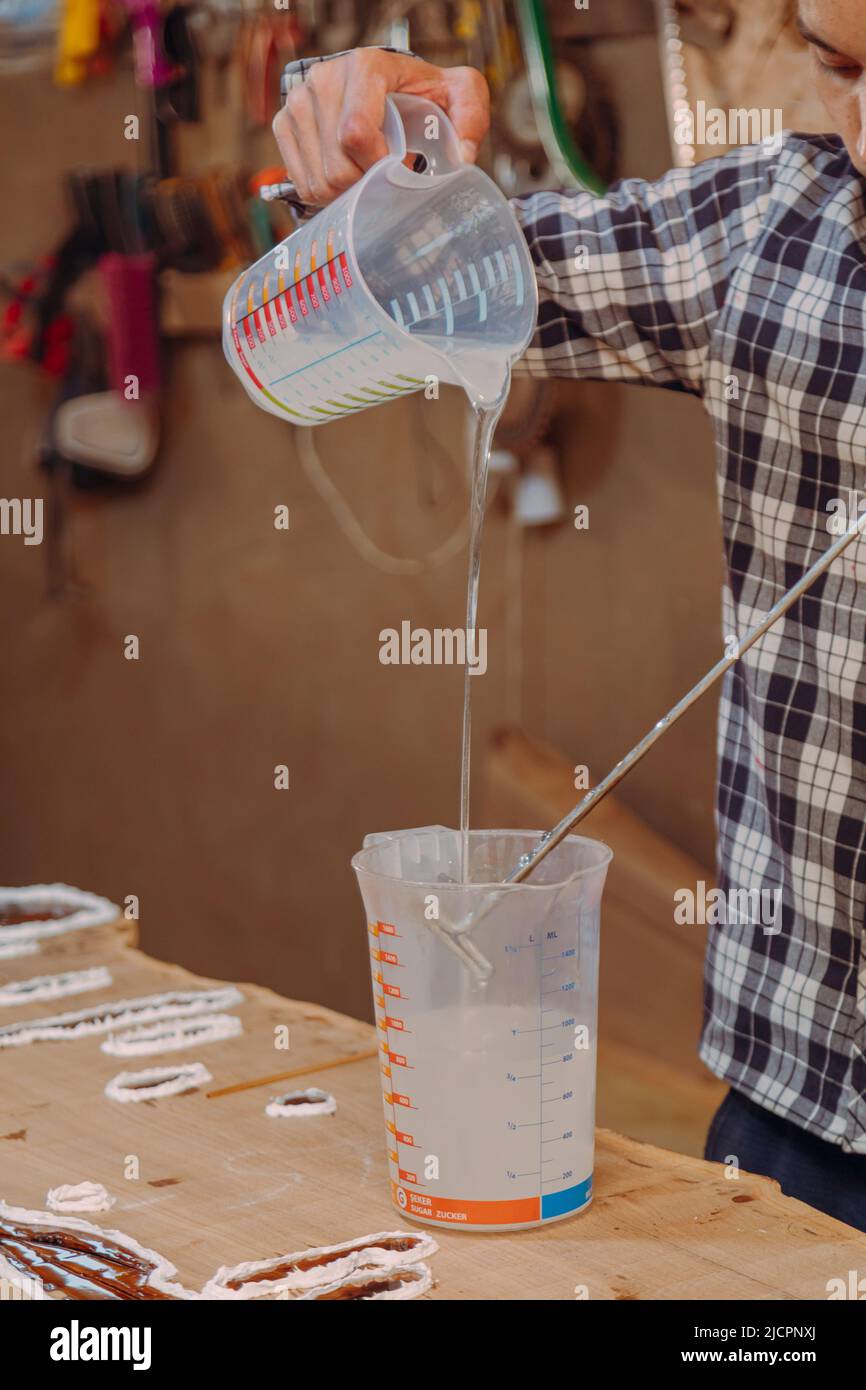 Carpenter preparing epoxy resin. Process of making a craft resin and ...