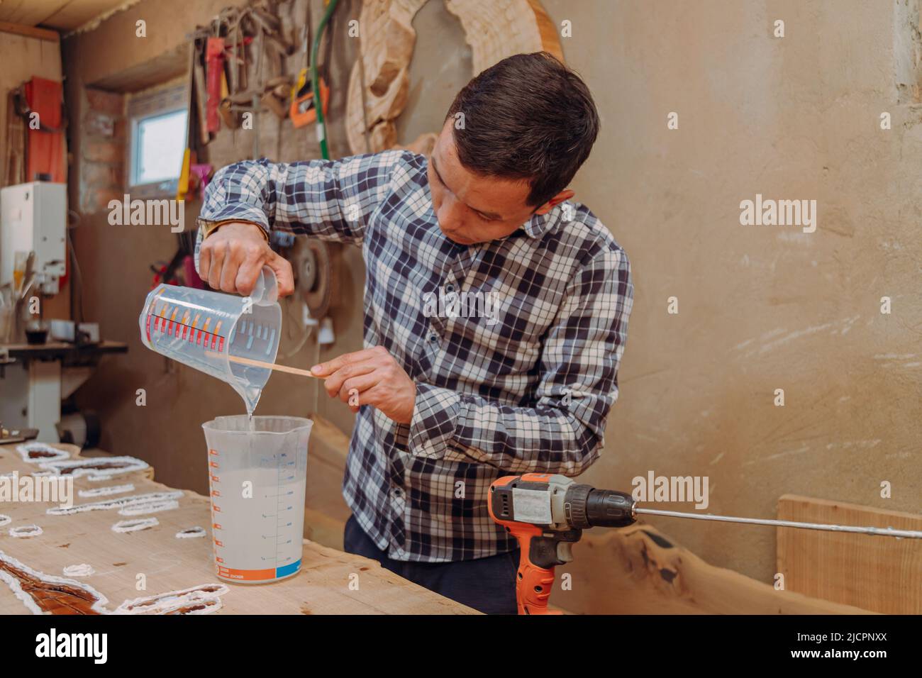 Carpenter preparing epoxy resin. Process of making a craft resin and ...