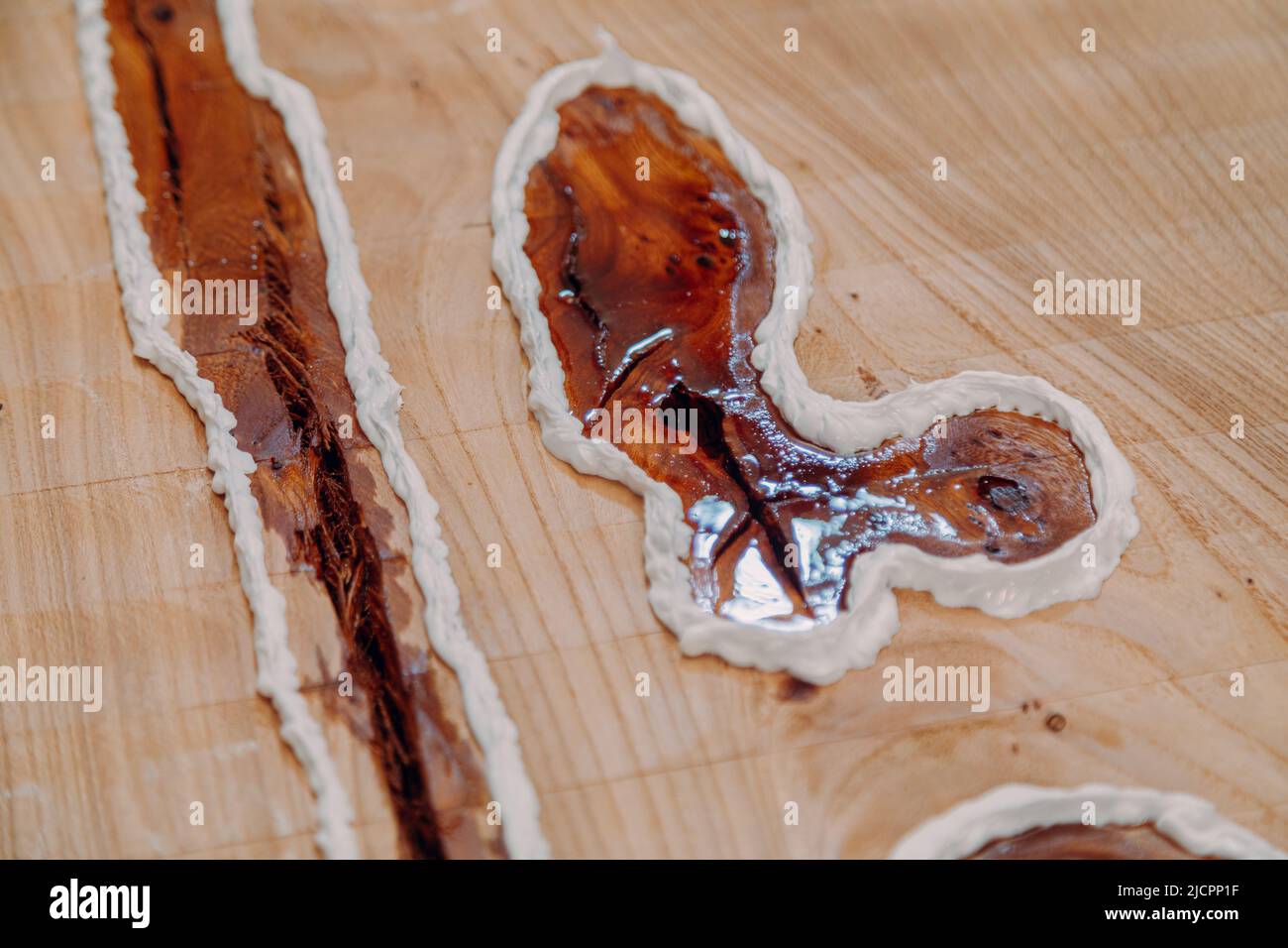 Closeup of dried epoxy resin in wood table. Process of making a craft ...
