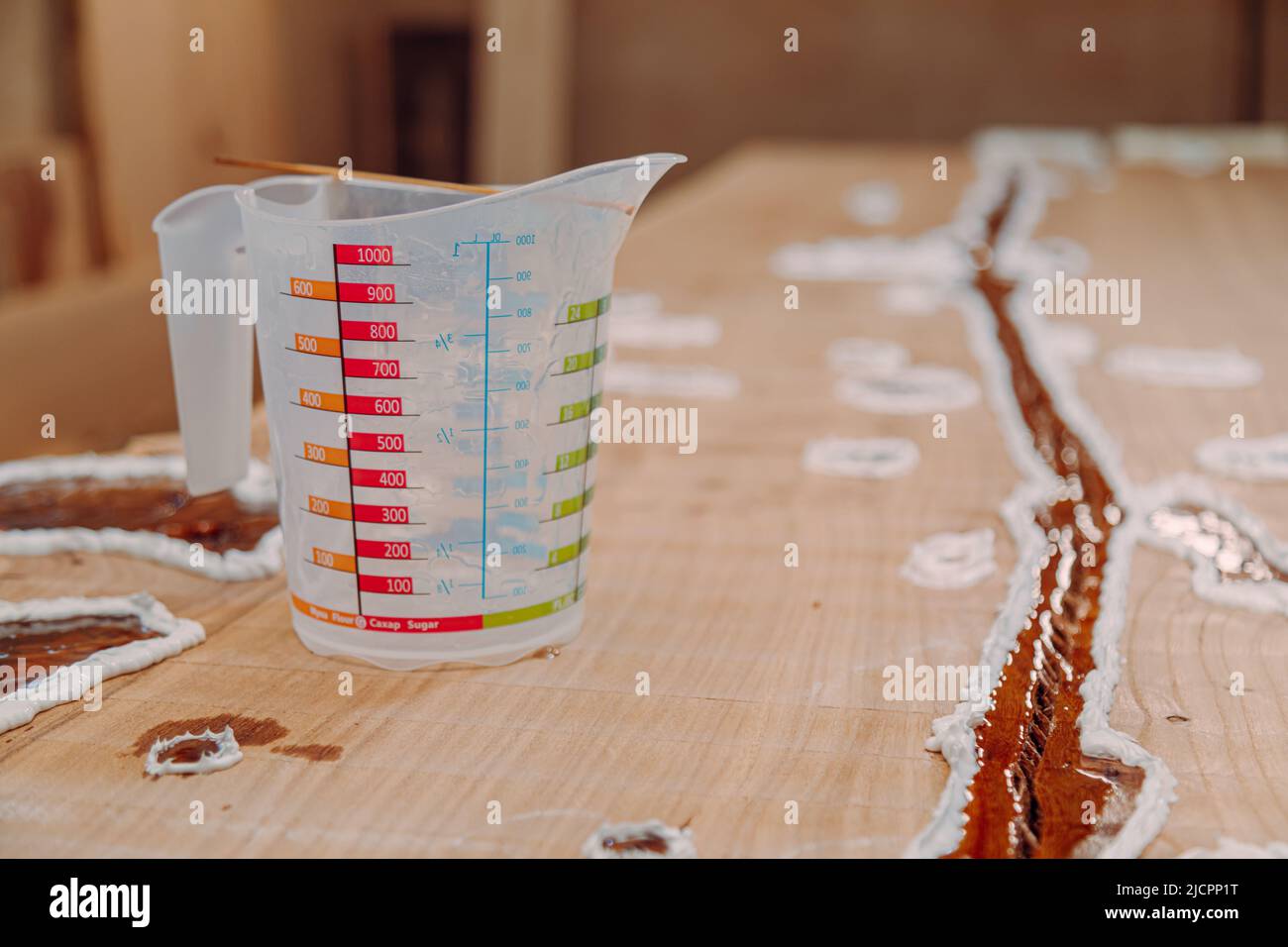 Liquid cup with epoxy resin on a wooden table. Process of making a ...