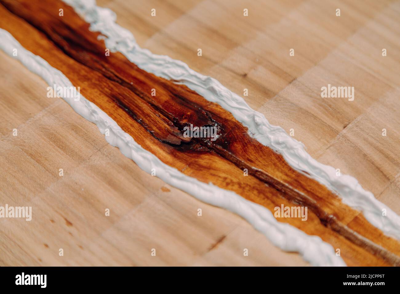 Closeup of dried epoxy resin in wood table. Process of making a craft ...
