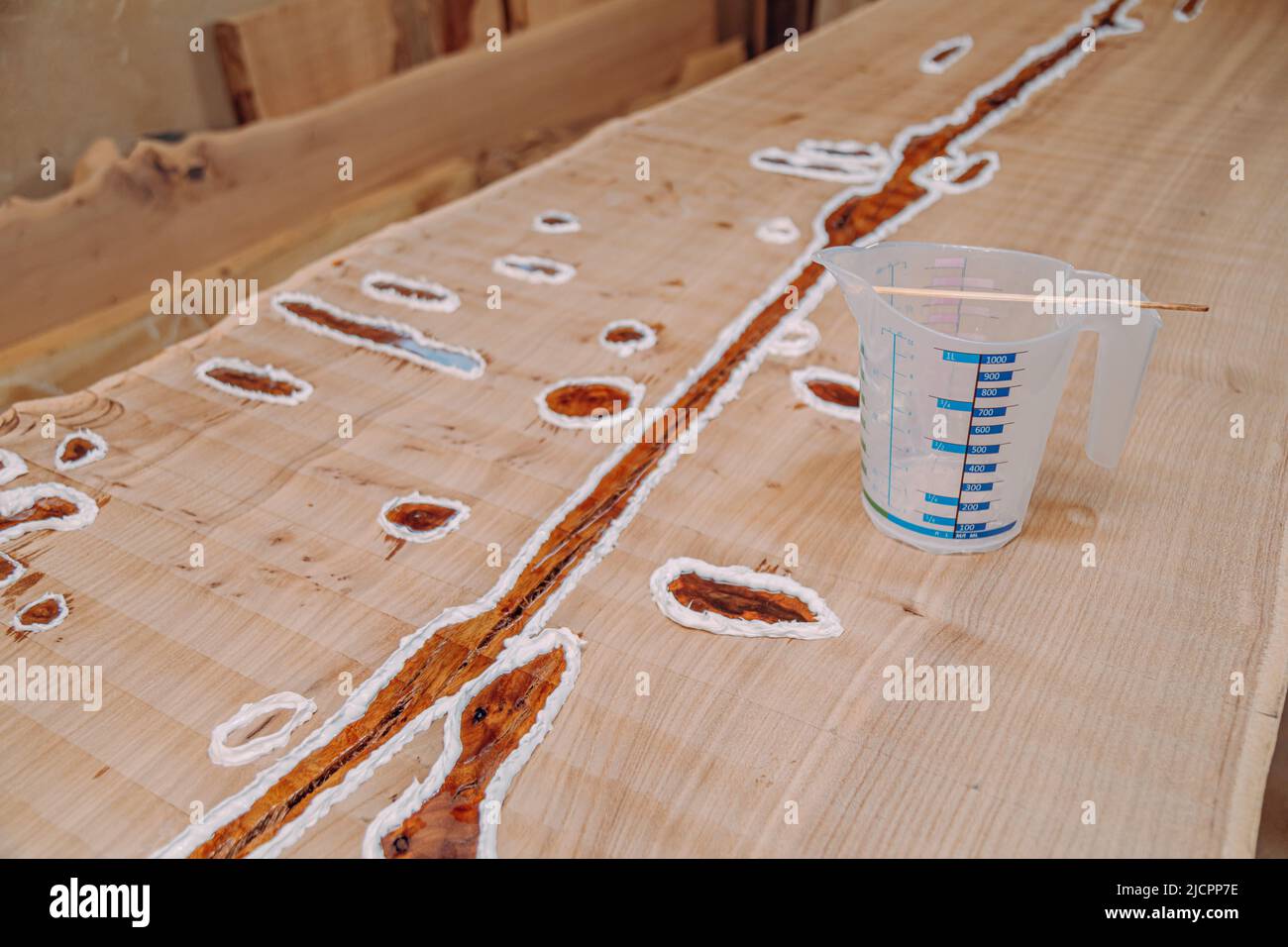 Liquid cup with epoxy resin on a wooden table. Process of making a ...