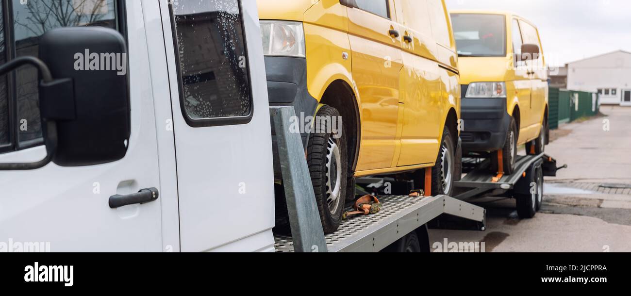 White small cargo truck car carrier loaded with two yellow van minibus ...