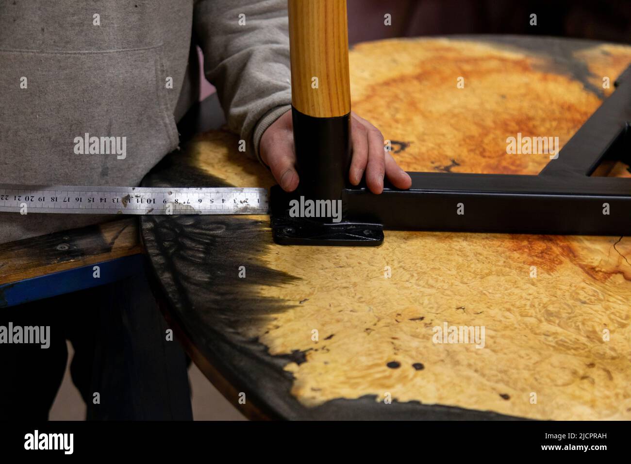 Closeup of person measuring the distance of a table leg with an iron ...