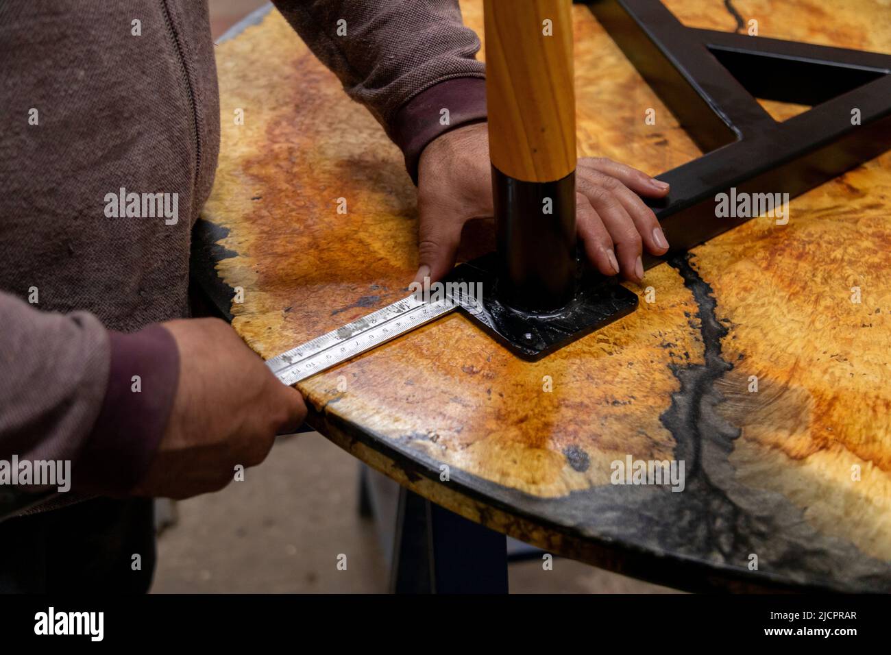 Closeup of person measuring the distance of a table leg with an iron ...