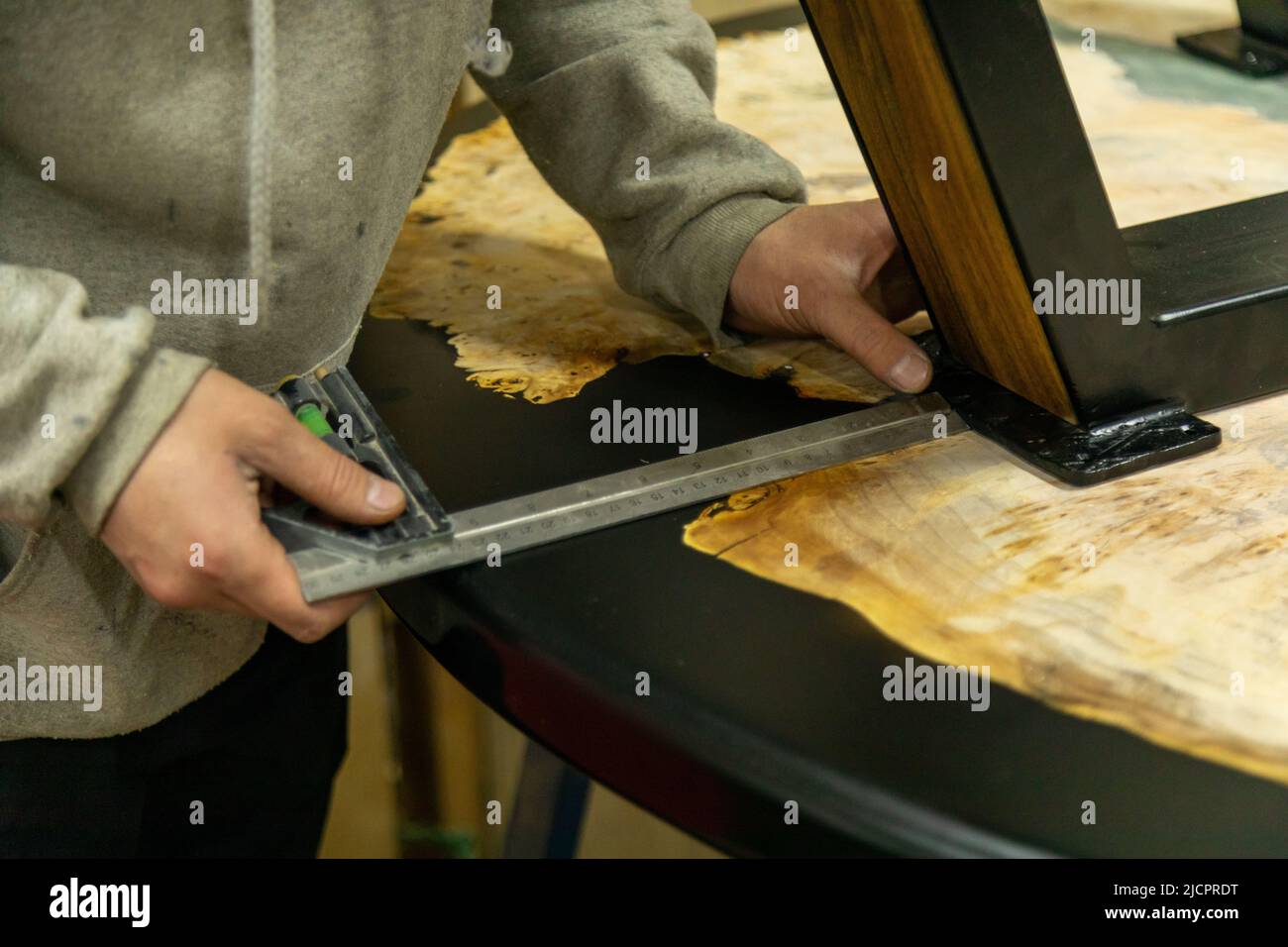 Closeup of person measuring the distance of a table leg with an iron ...