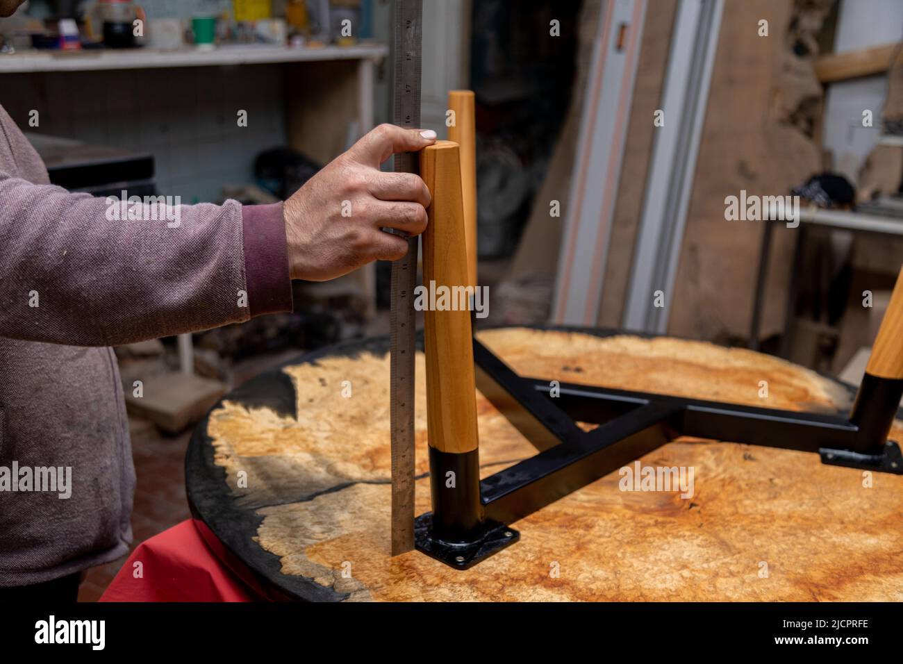Closeup of person measuring the distance of a table leg with an iron ...